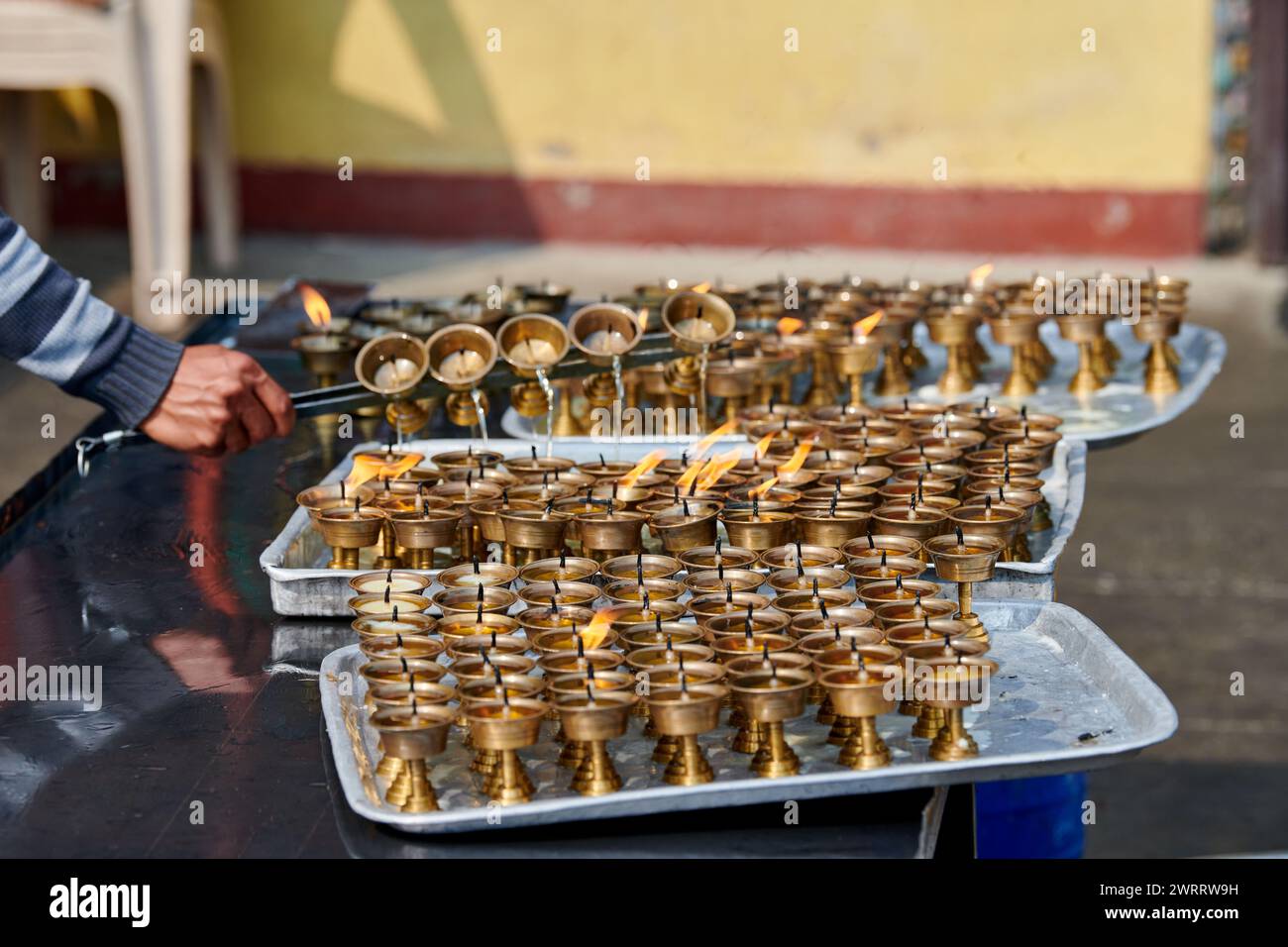 Nepali temple staff pour out candle oil after wick burns out for ...