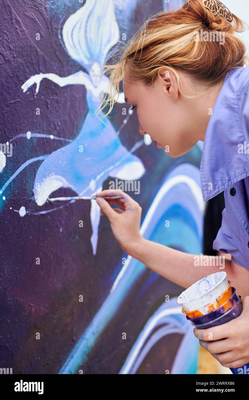 Female painter draws picture with paintbrush on canvas for outdoor ...