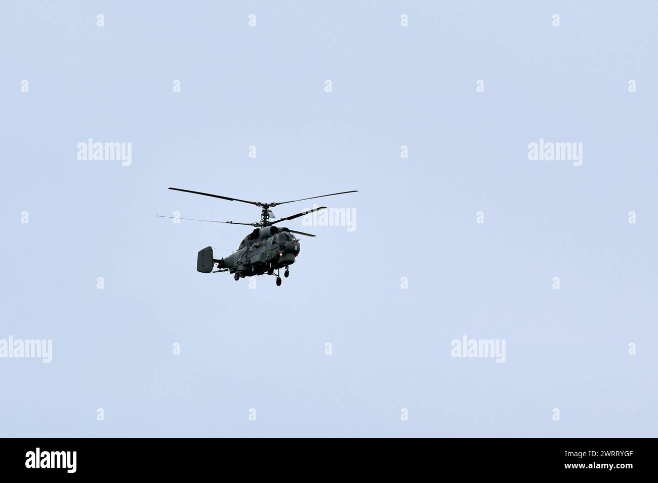 Russian military helicopter armed with missiles flies in blue sky ...