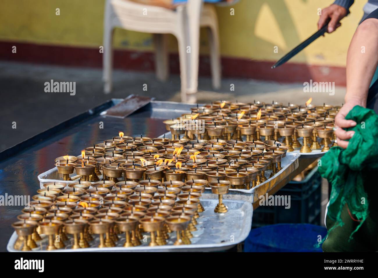 Nepali temple staff pour out candle oil after wick burns out for ...