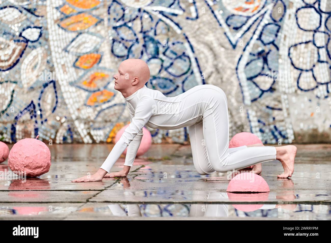 Outdoor dance of young ballerina girl with alopecia in white futuristic ...