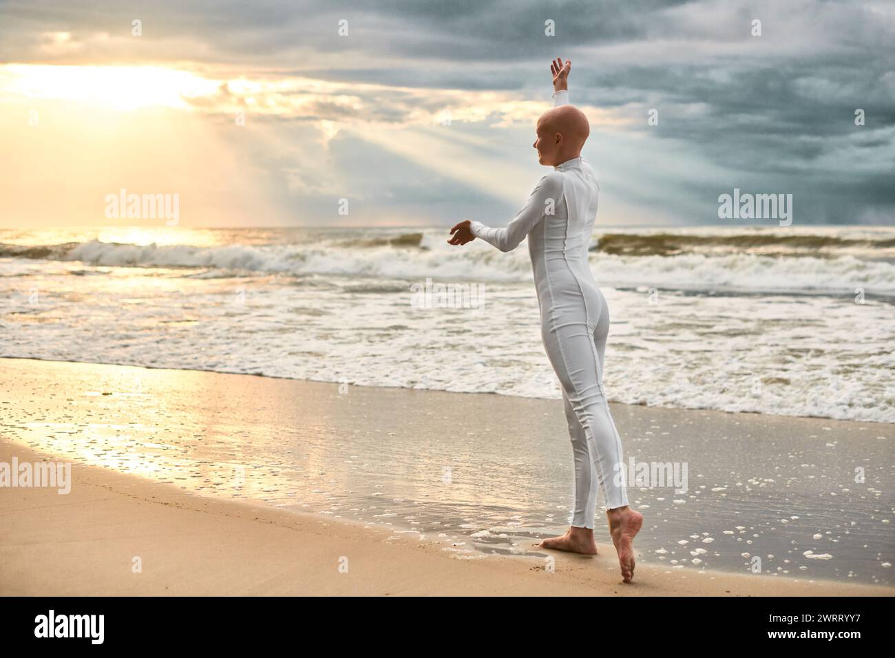 Young hairless ballerina with alopecia in white futuristic suit dancing ...