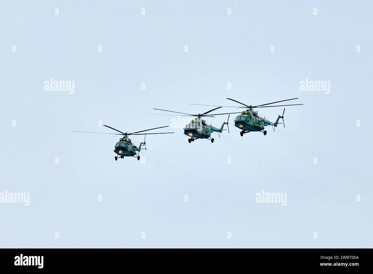 Three Russian military helicopters armed with missiles flies in blue ...