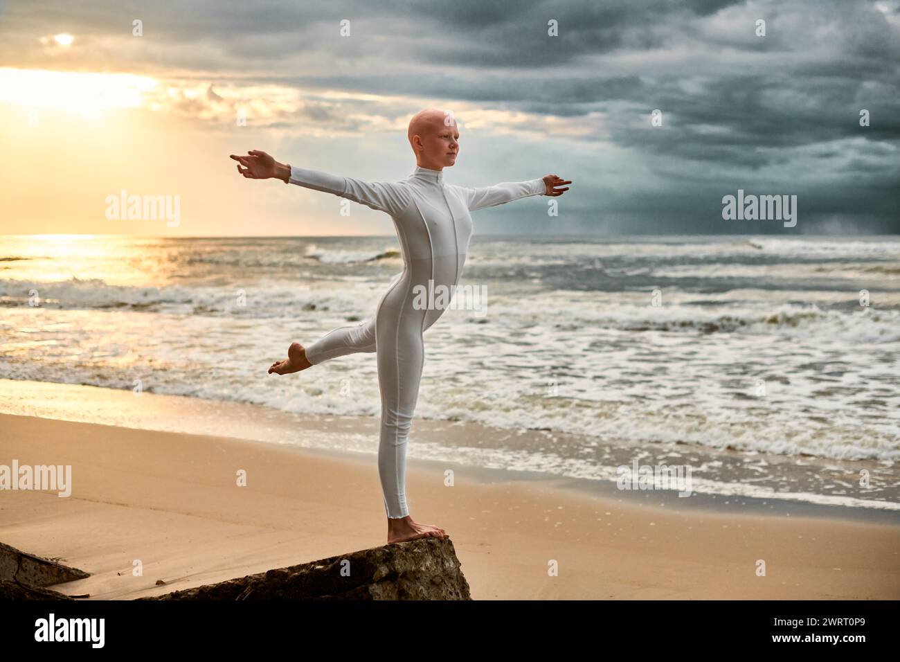 Young hairless ballerina with alopecia in white futuristic suit dancing ...