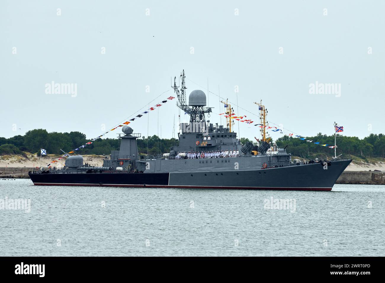 Russian naval ship with signal nautical flags anchored along shoreline ...