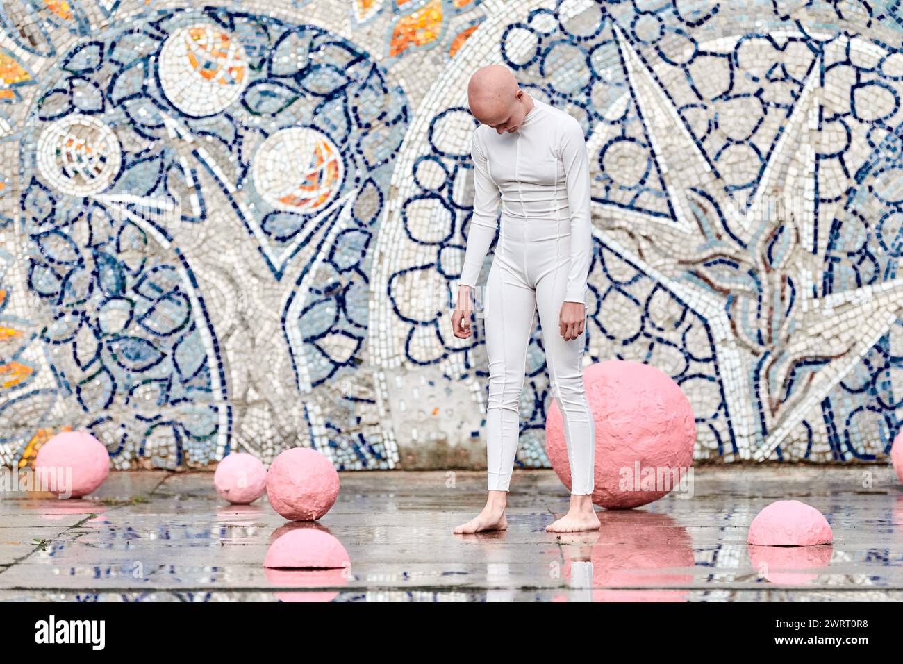 Young hairless girl ballerina with alopecia in white futuristic suit ...