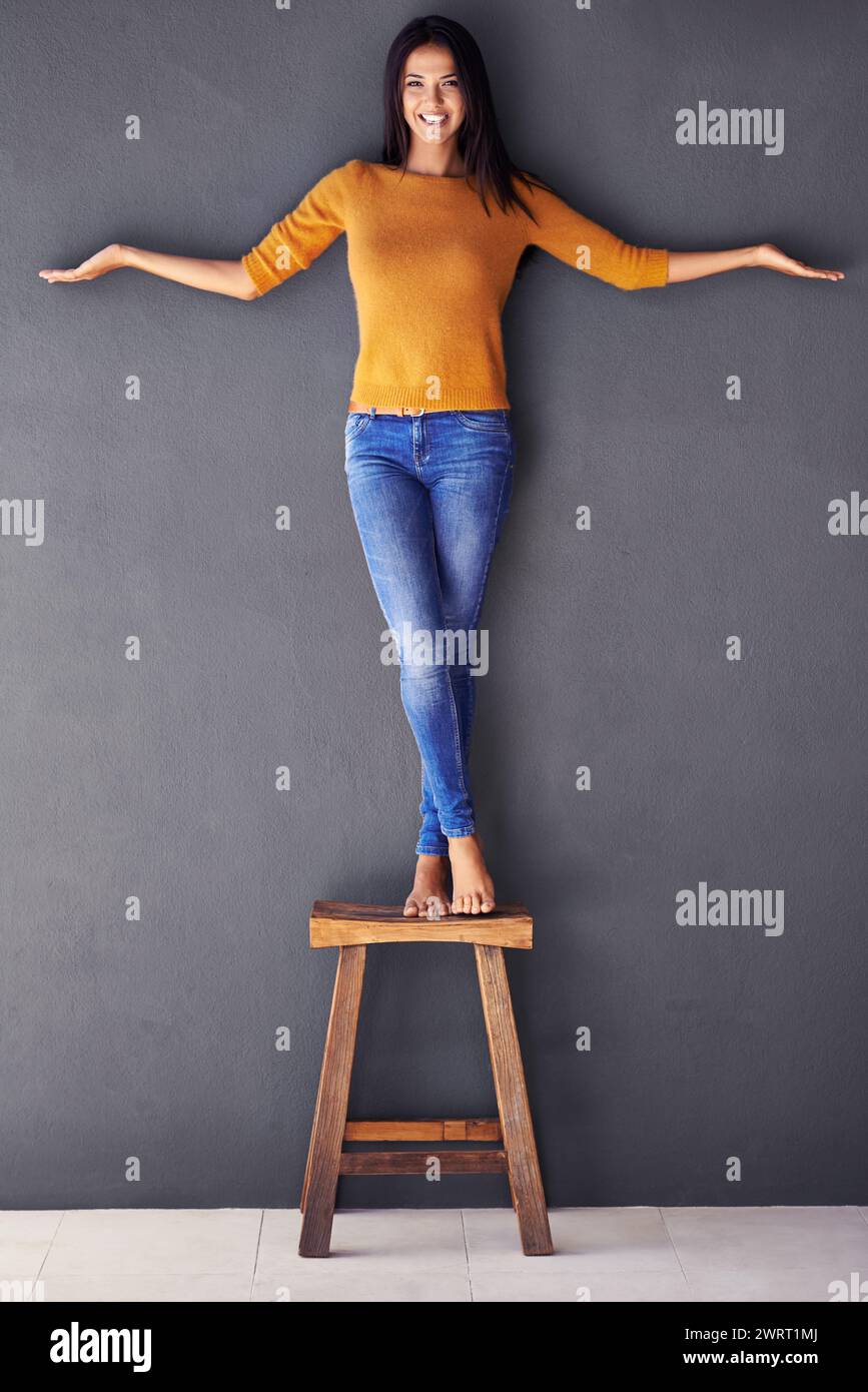 Woman, fashion and stand on chair in portrait, smile and balance on ...