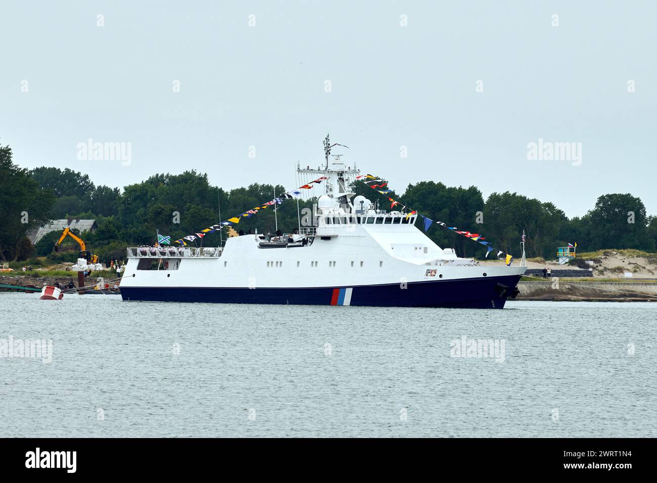 Russian naval ship with signal nautical flags anchored along shoreline ...