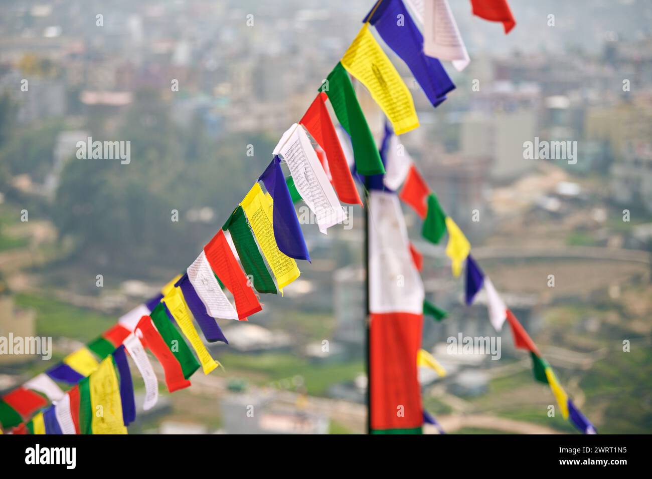 Colorful Tibetan prayer flags on blurred Kathmandu cityscape background ...