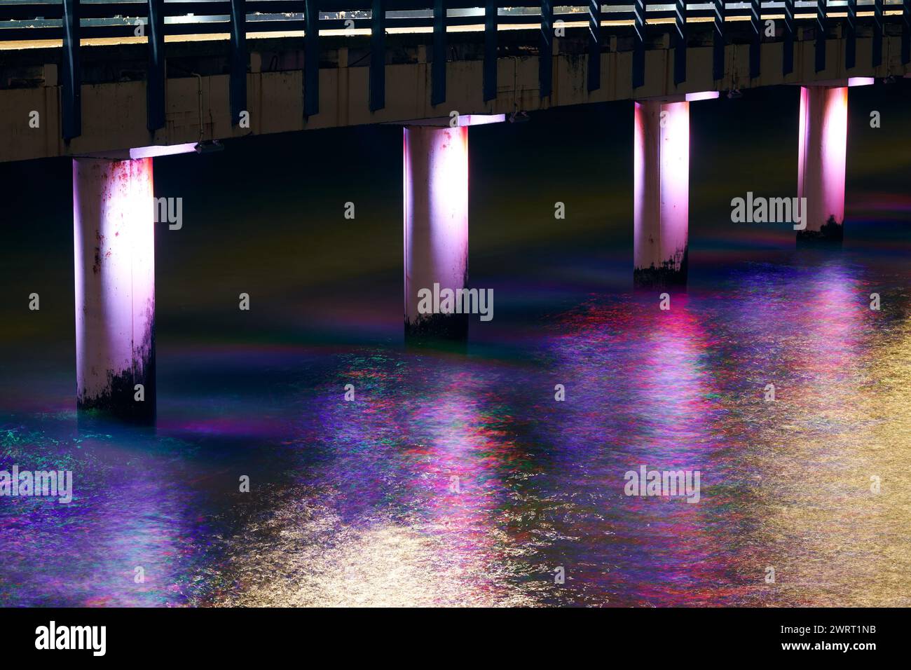 Sea pier adorned multicolored twinkling lights at night symbolizes ...