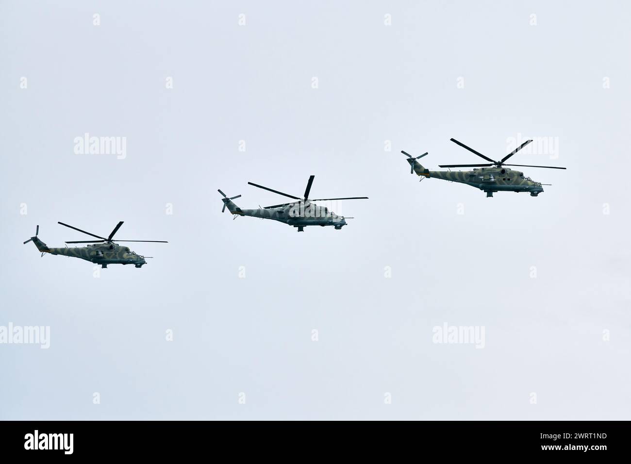 Three Russian military helicopters armed with missiles flies in blue ...