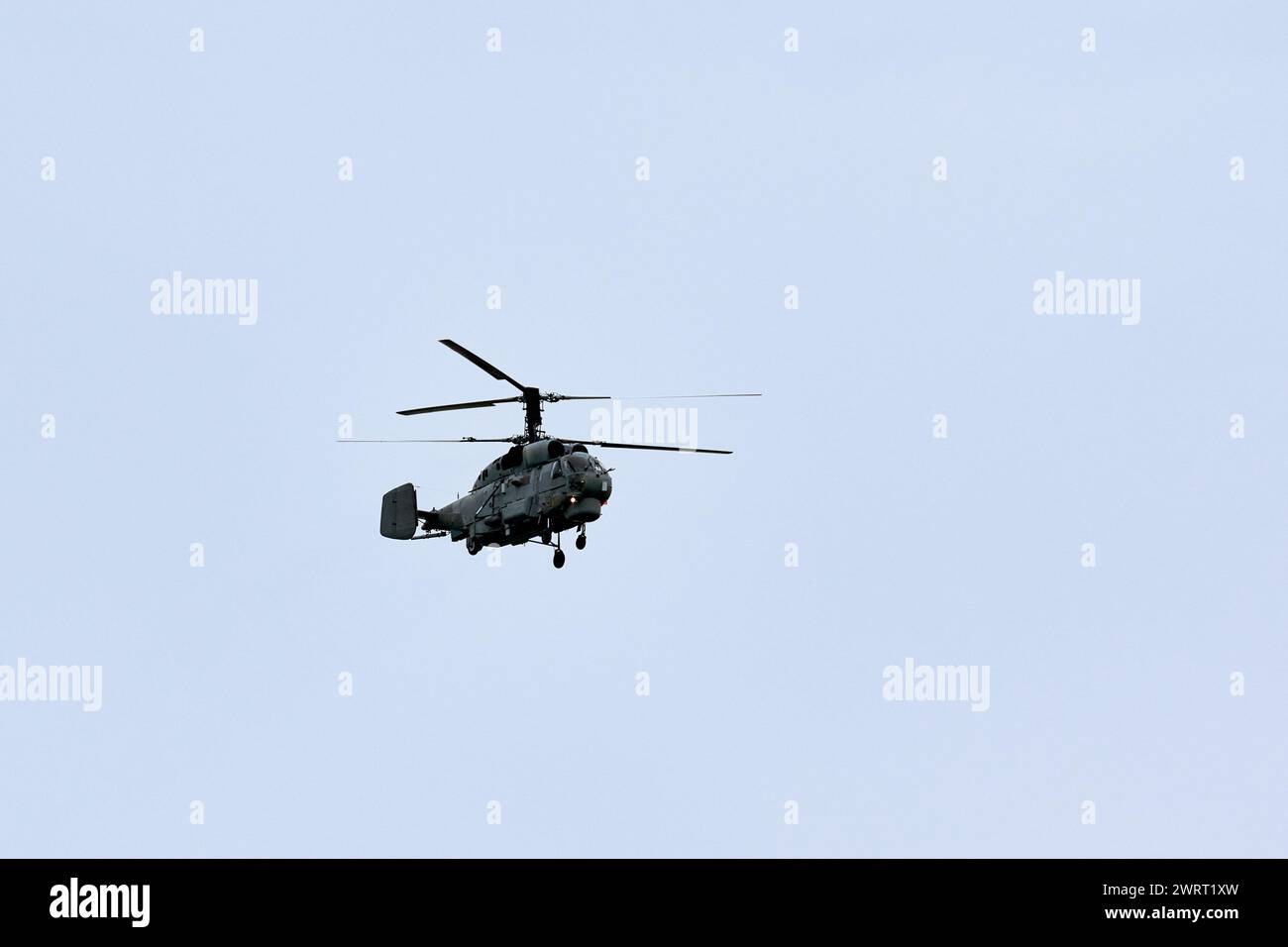 Russian military helicopter armed with missiles flies in blue sky ...