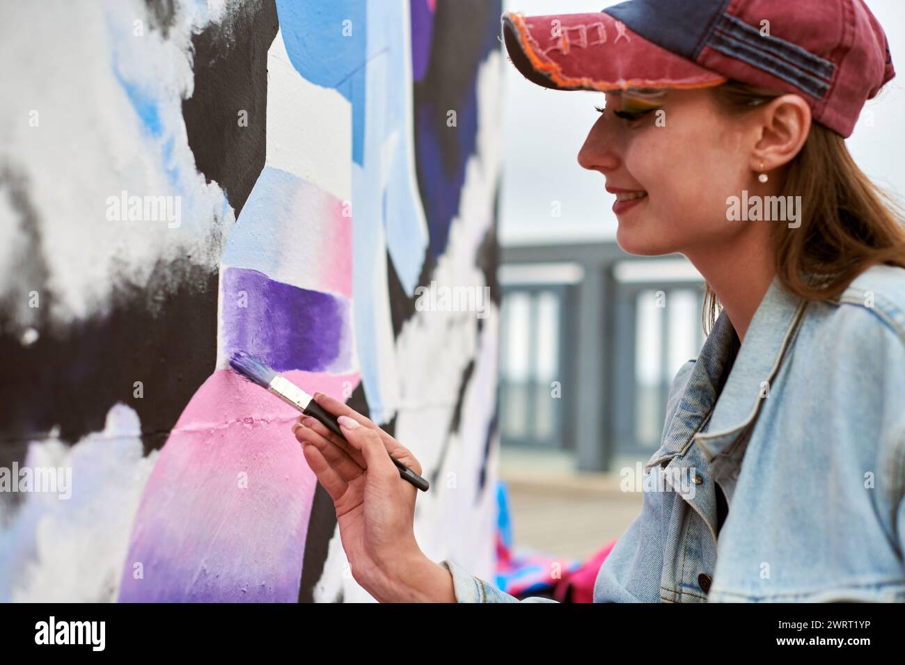 Female painter draws picture with paintbrush on canvas for outdoor ...