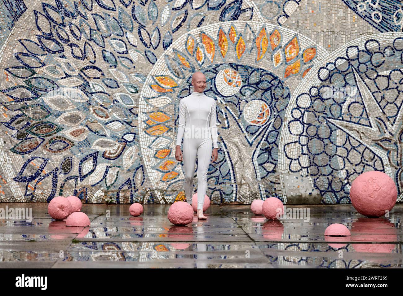 Young hairless girl ballerina with alopecia in white futuristic suit ...