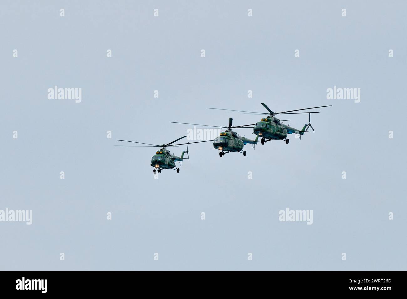 Three Russian military helicopters armed with missiles flies in blue ...