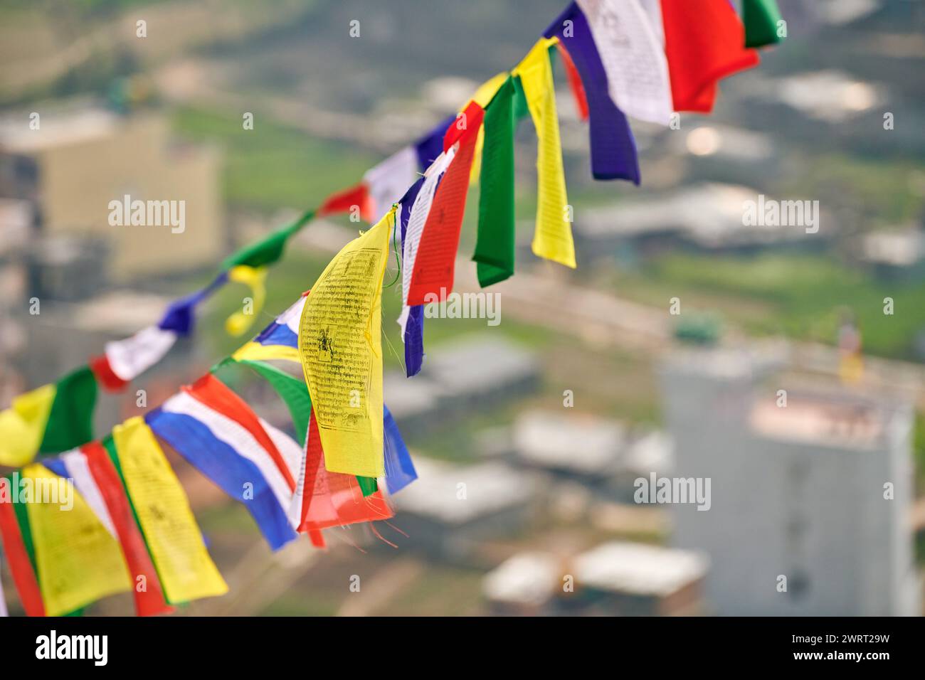 Colorful Tibetan prayer flags on blurred Kathmandu cityscape background ...