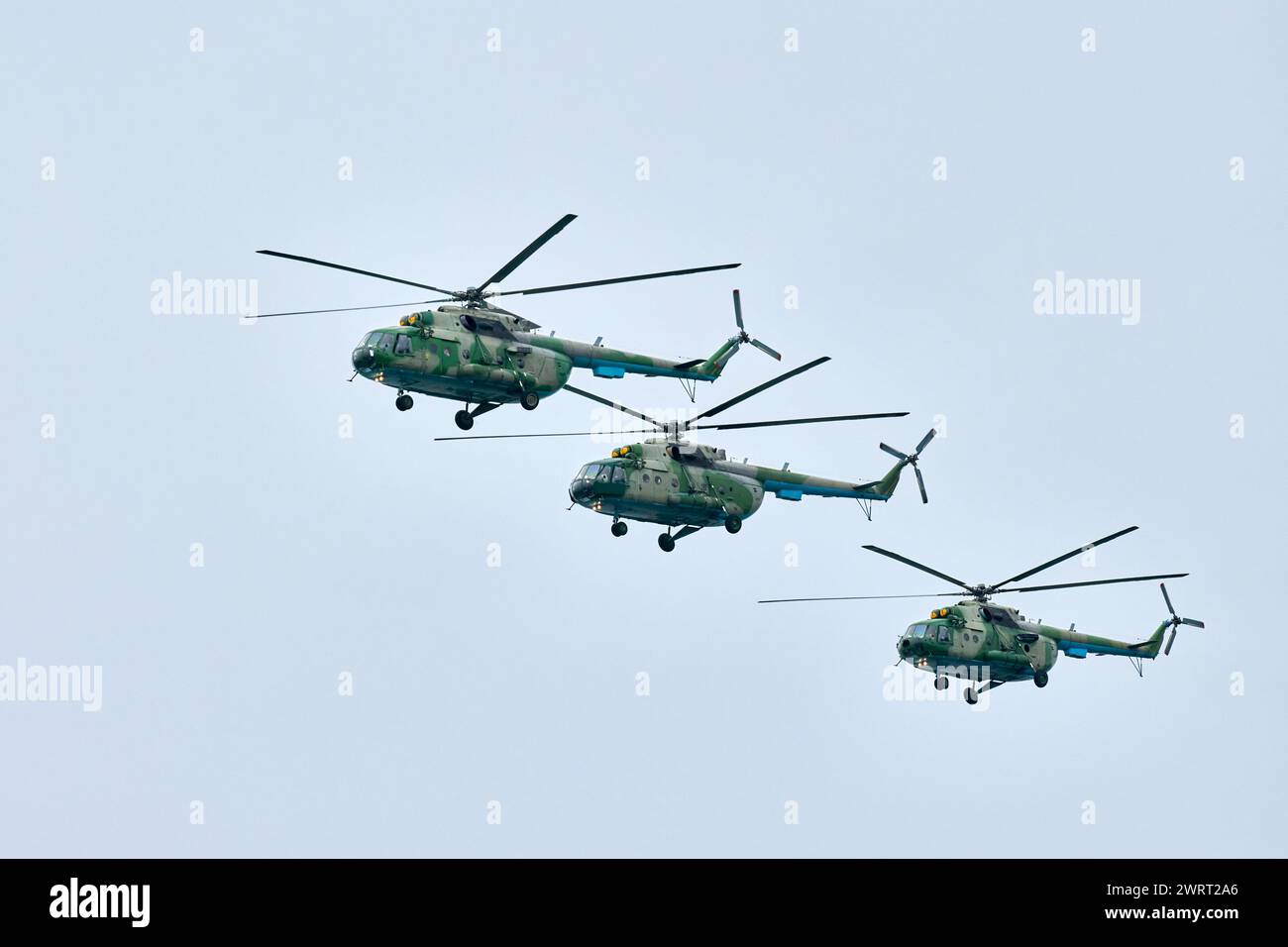 Three Russian military helicopters armed with missiles flies in blue ...