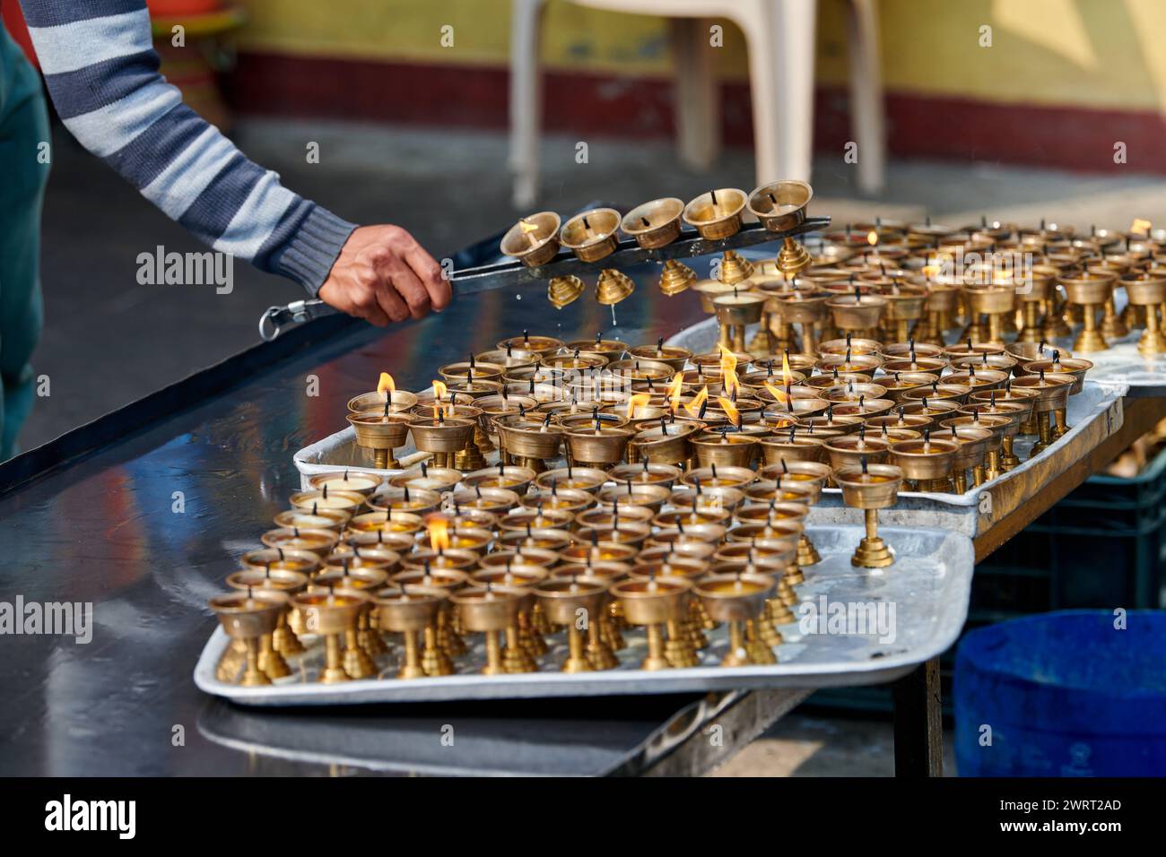 Nepali temple staff pour out candle oil after wick burns out for ...
