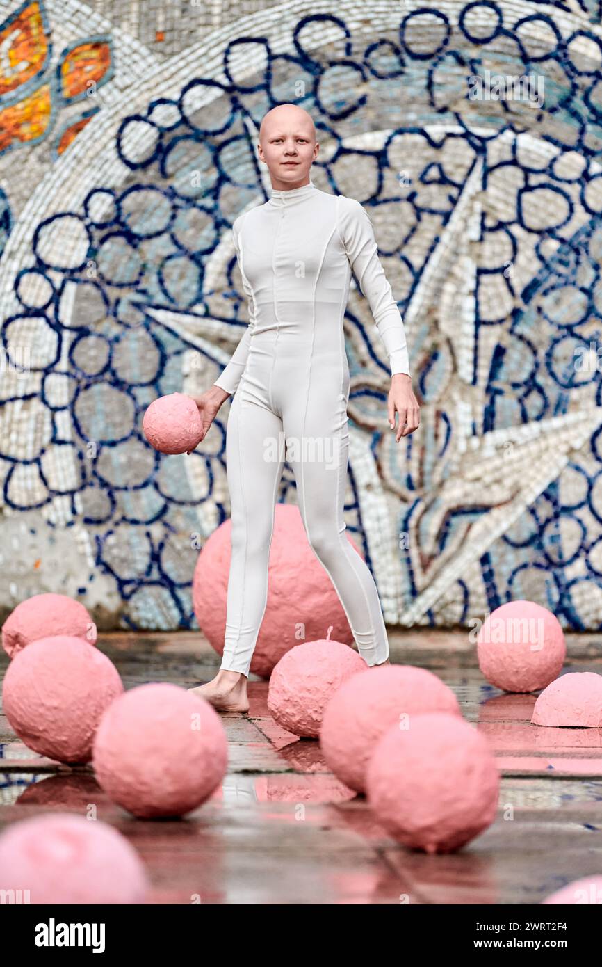 Young hairless girl ballerina with alopecia in white futuristic suit ...
