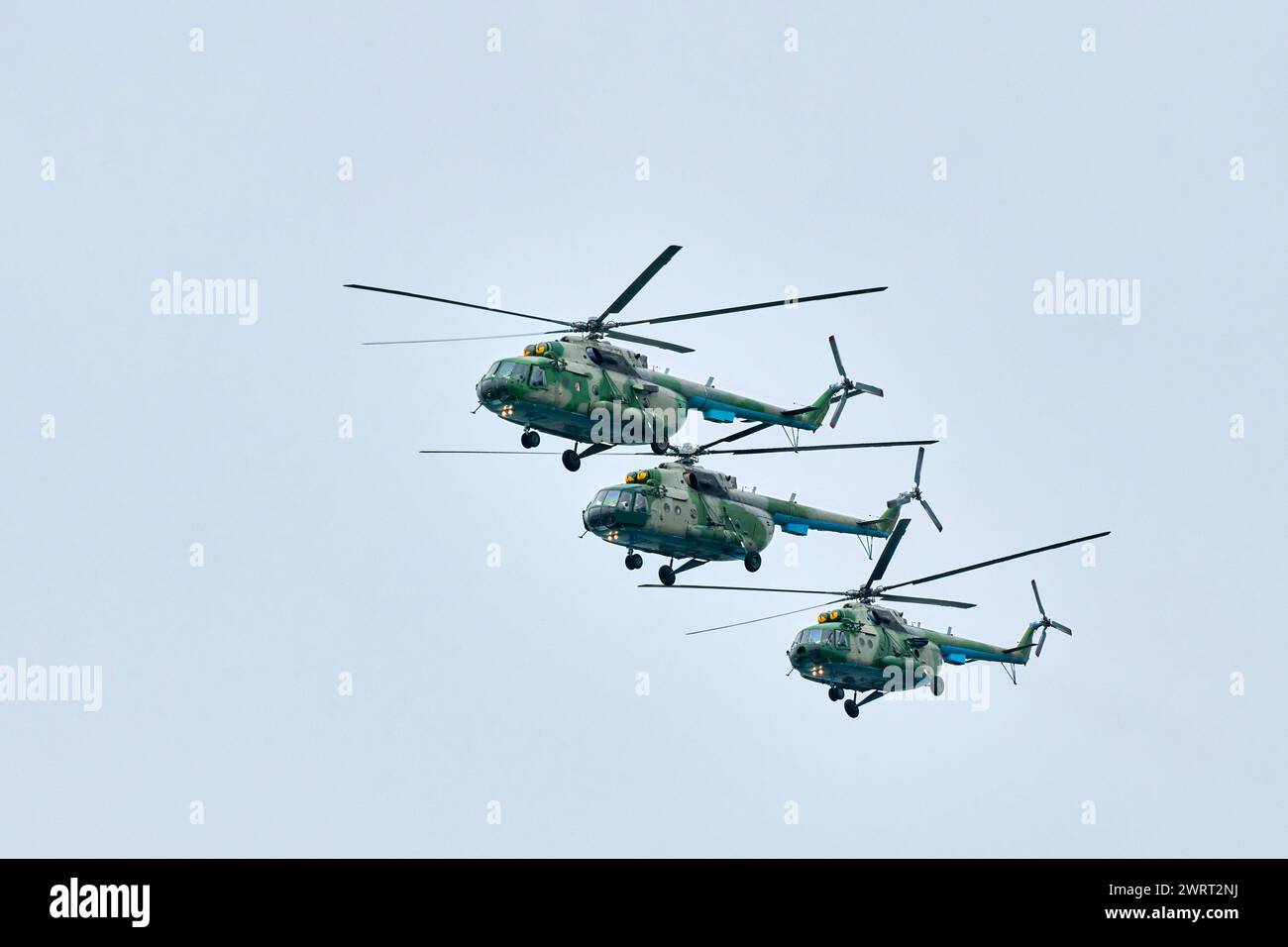 Three Russian military helicopters armed with missiles flies in blue ...