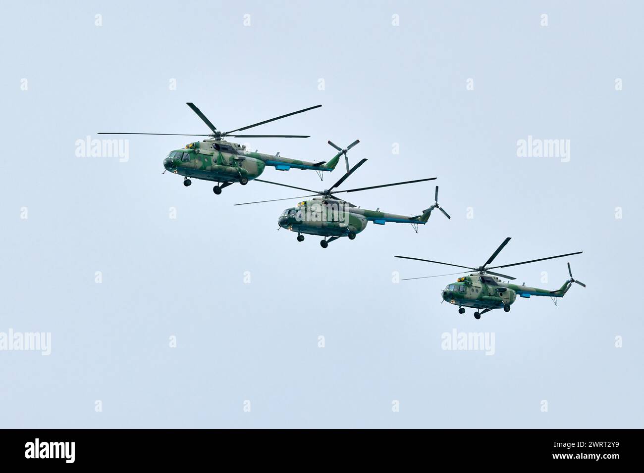 Three Russian military helicopters armed with missiles flies in blue ...