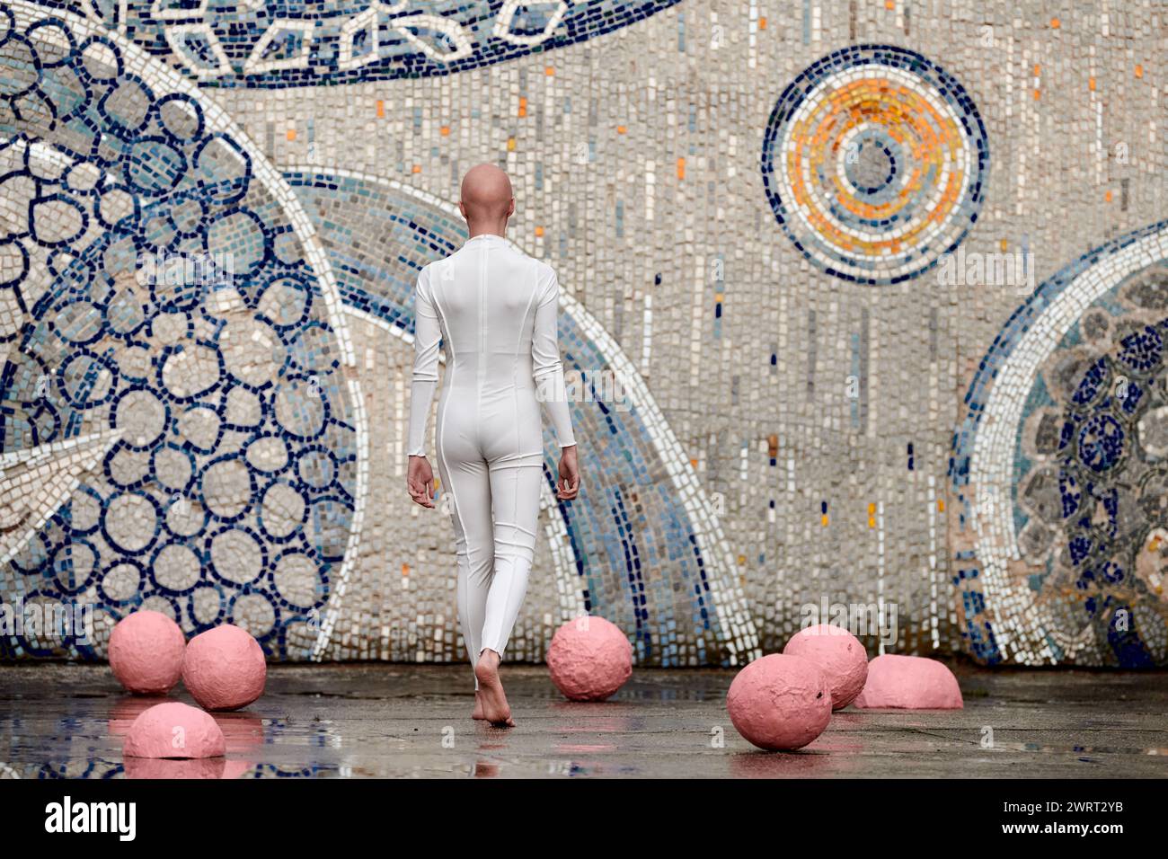 Young hairless girl ballerina with alopecia in white futuristic suit ...