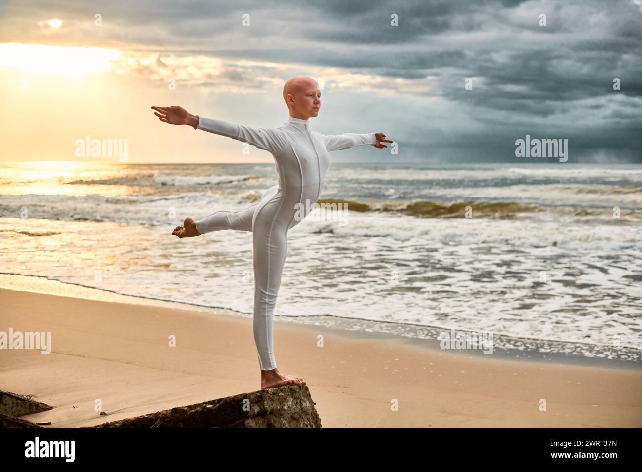 Young hairless ballerina with alopecia in white futuristic suit dancing ...