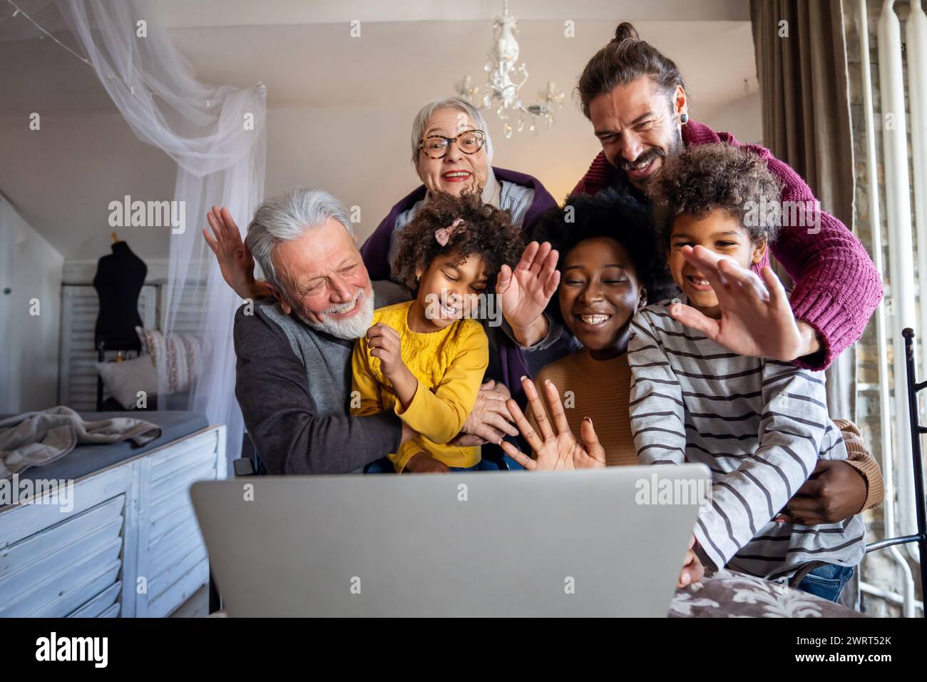 Happy multi-generation diverse family gathering around notebook and ...