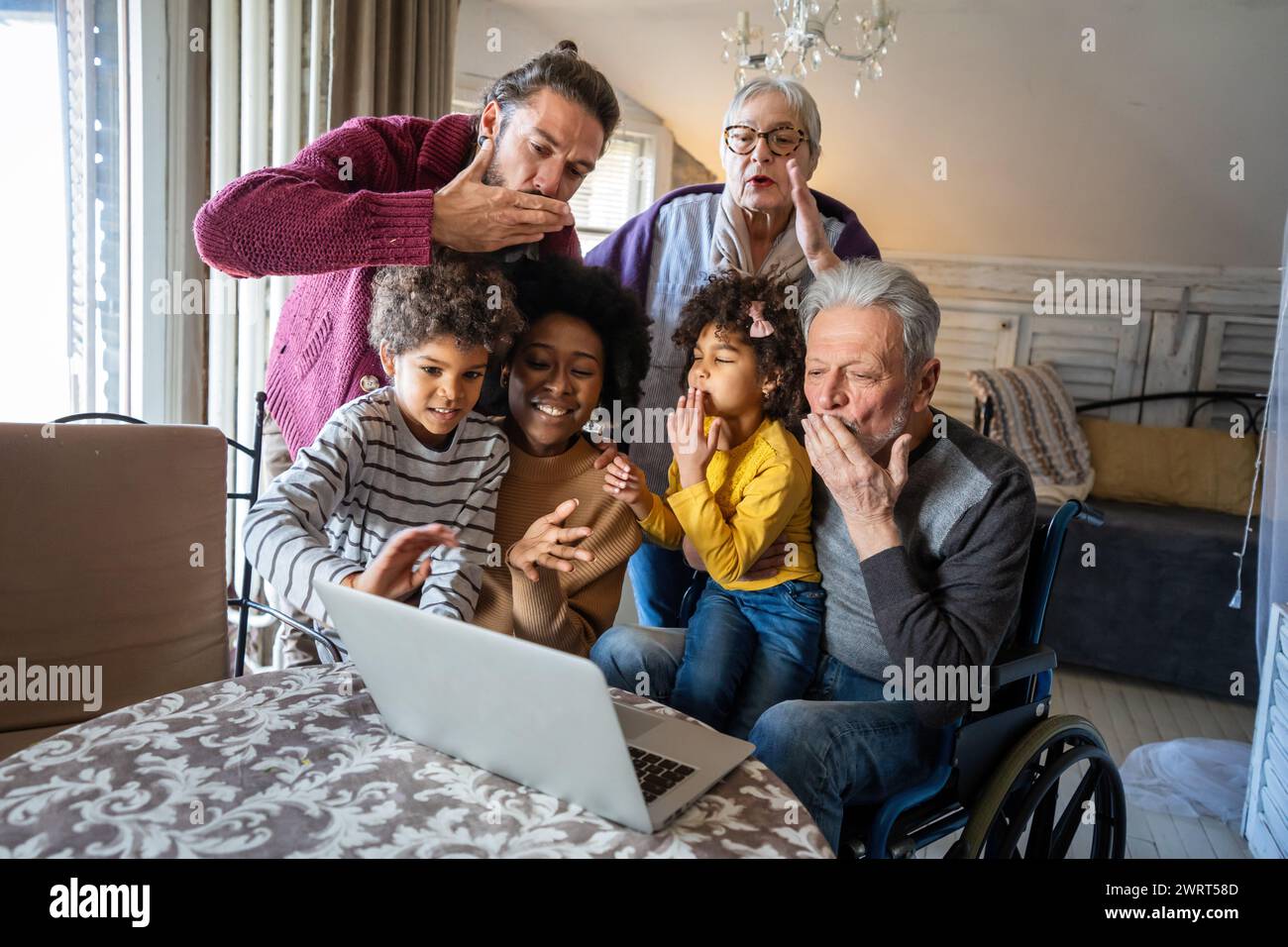 Extended multiethnic family together at home during video call. People ...