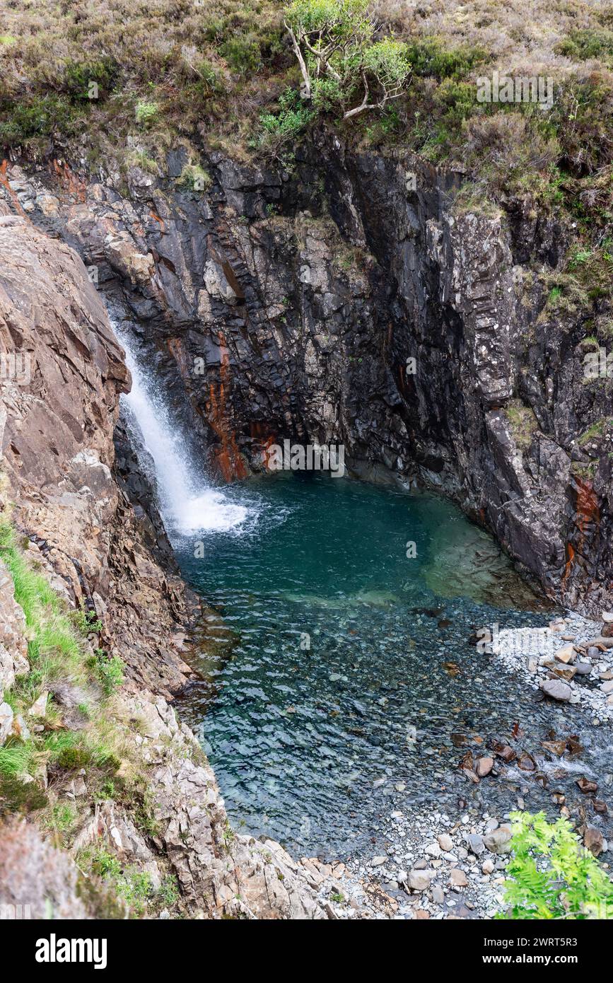 The vertical shot captures the dynamic flow of a waterfall into a ...