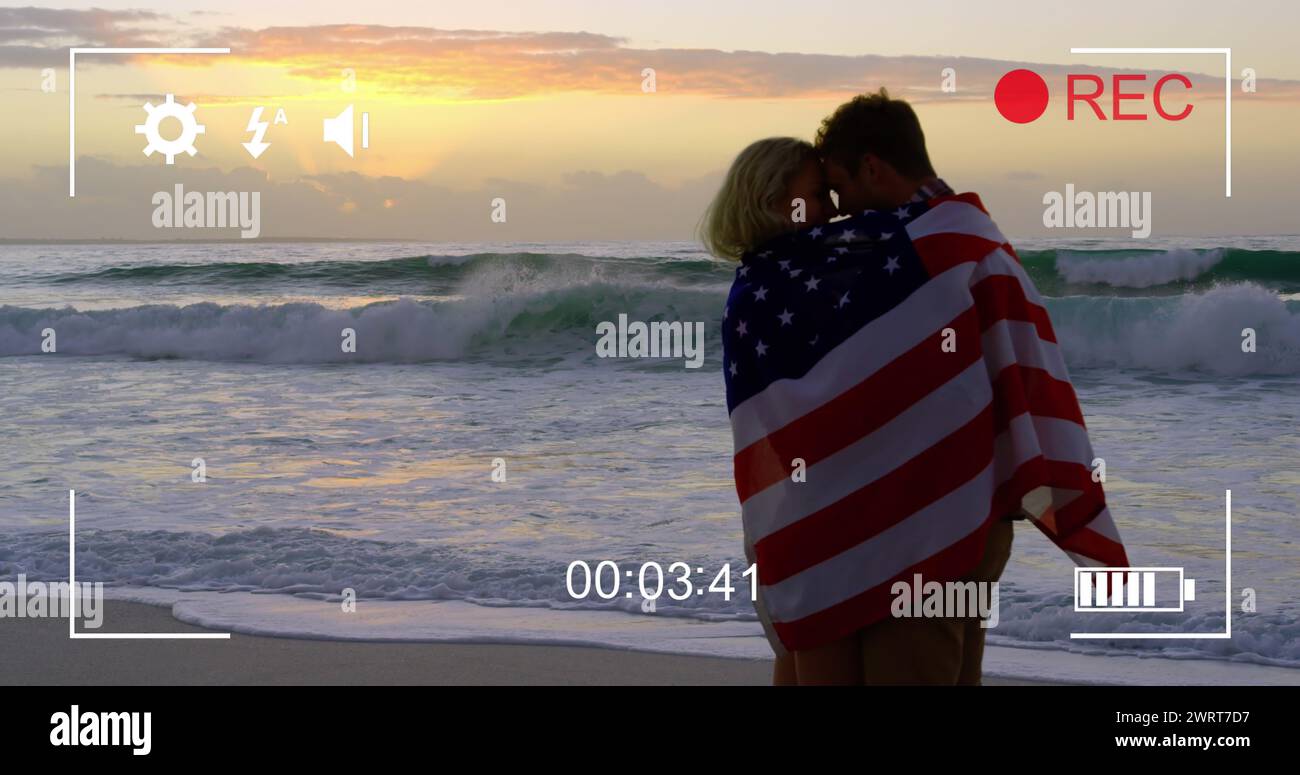 Young couple wrapped in American flag on beach, captured on camera in ...