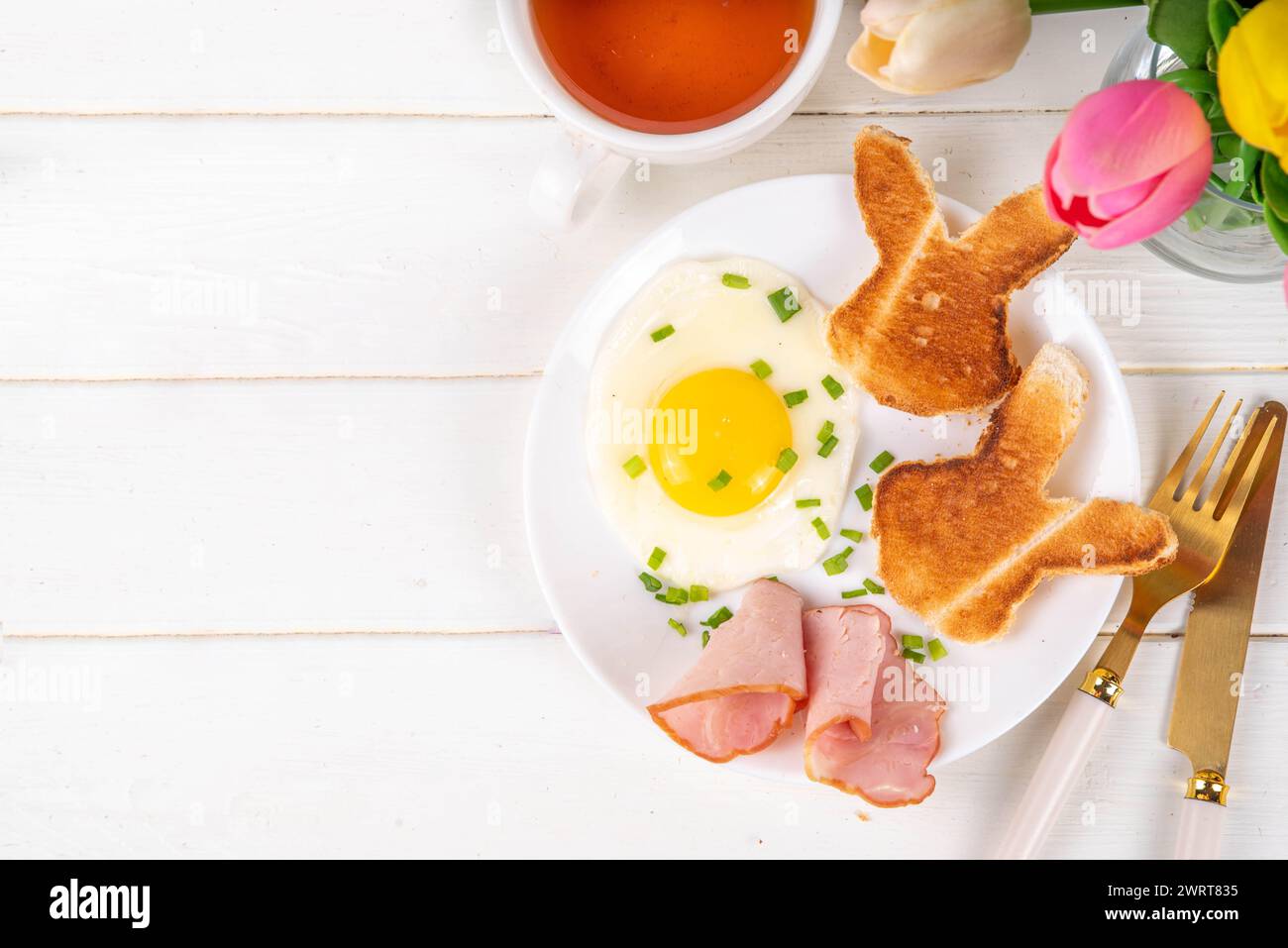 Easter breakfast or brunch with fried eggs, bacon slices and toasted ...
