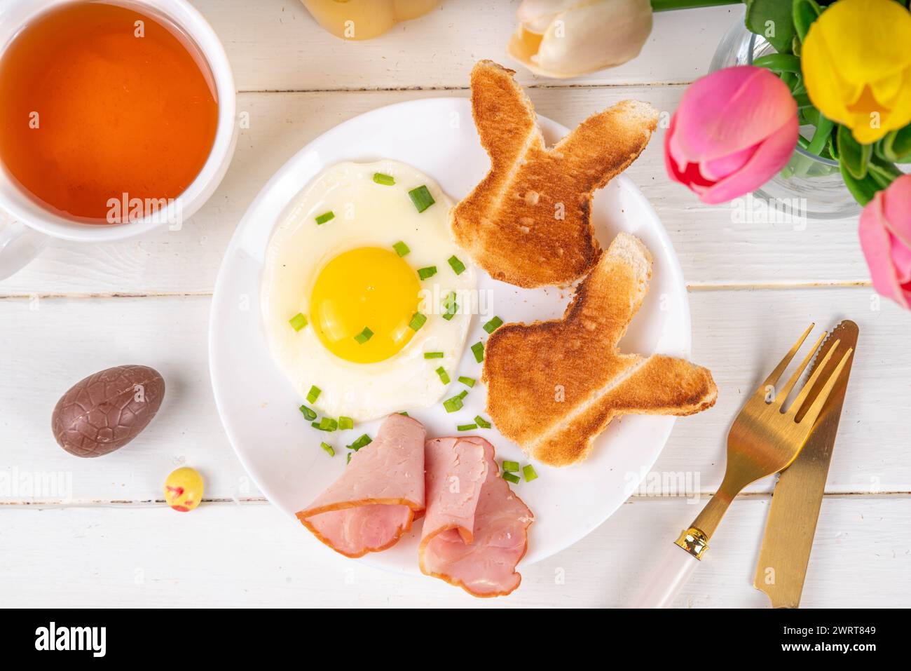 Easter breakfast or brunch with fried eggs, bacon slices and toasted ...