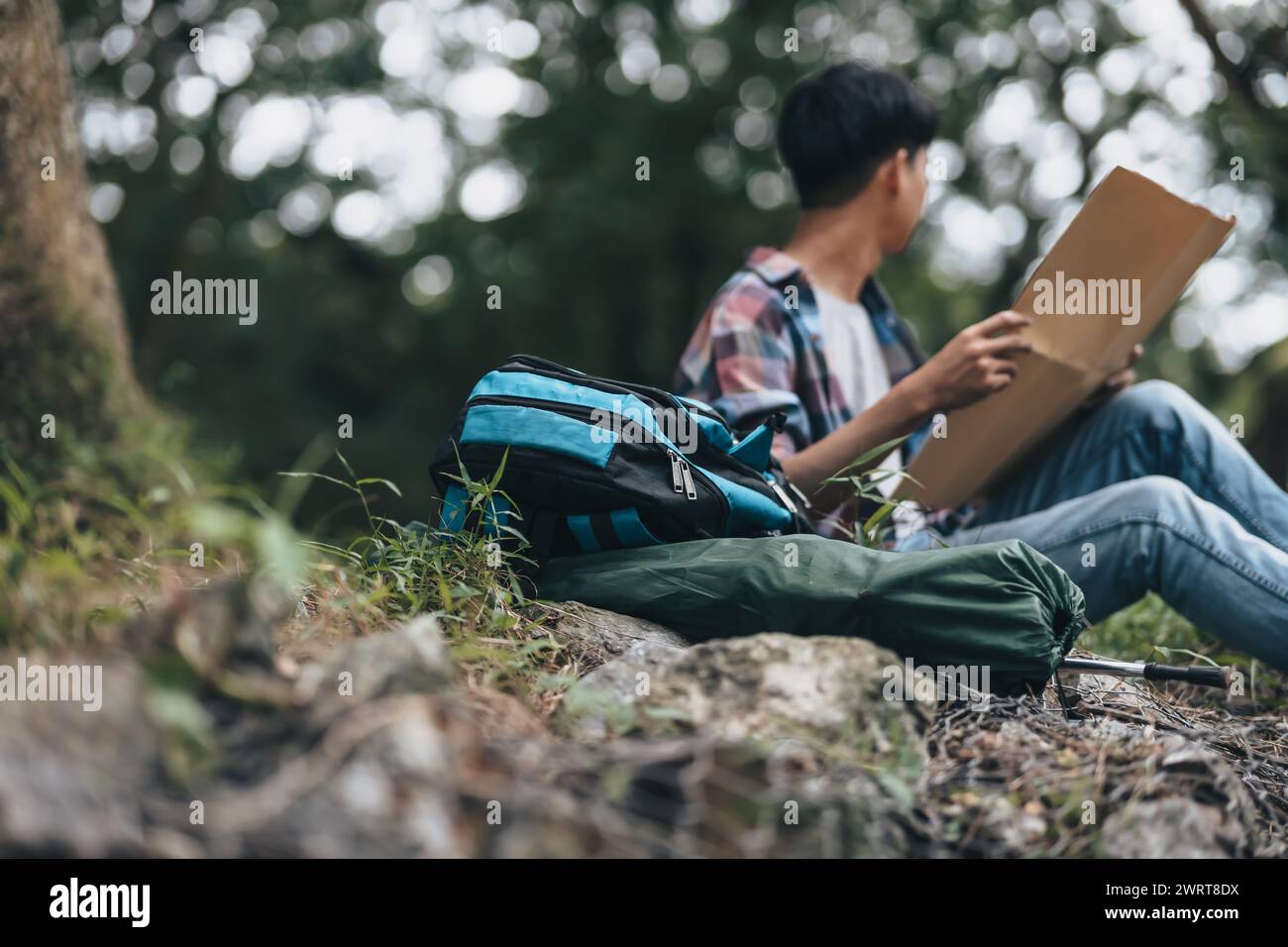 Bag on the ground and Lost hiker with backpack checks map to find ...