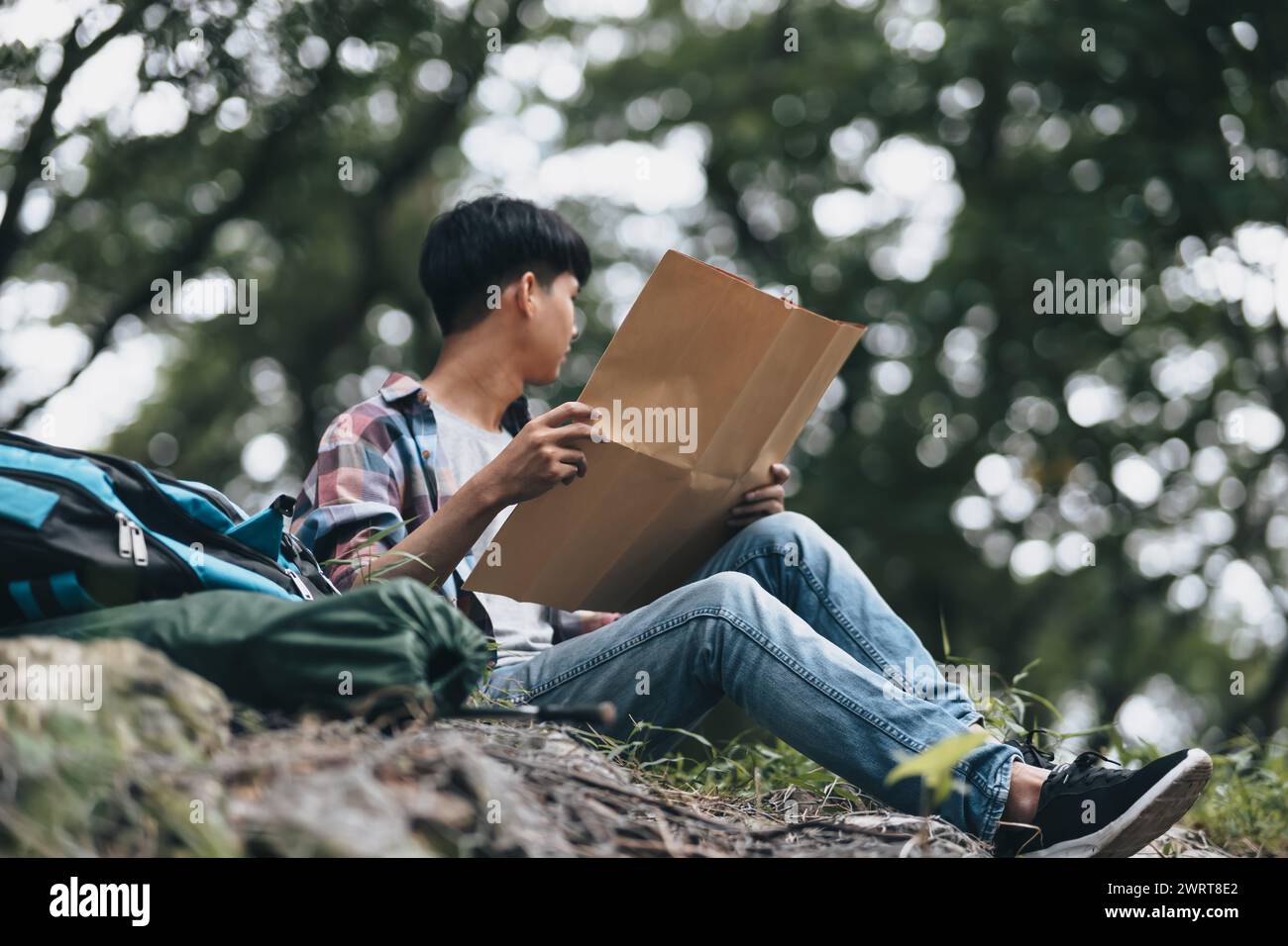 Lost hiker with backpack checks map to find directions near the river ...
