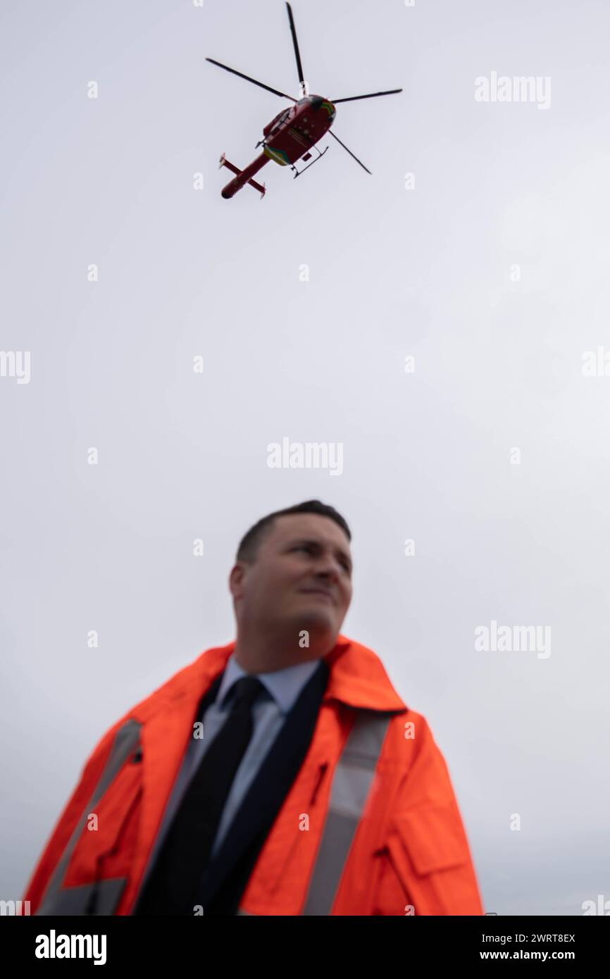 Shadow health secretary Wes Streeting watches the helicopter take off ...