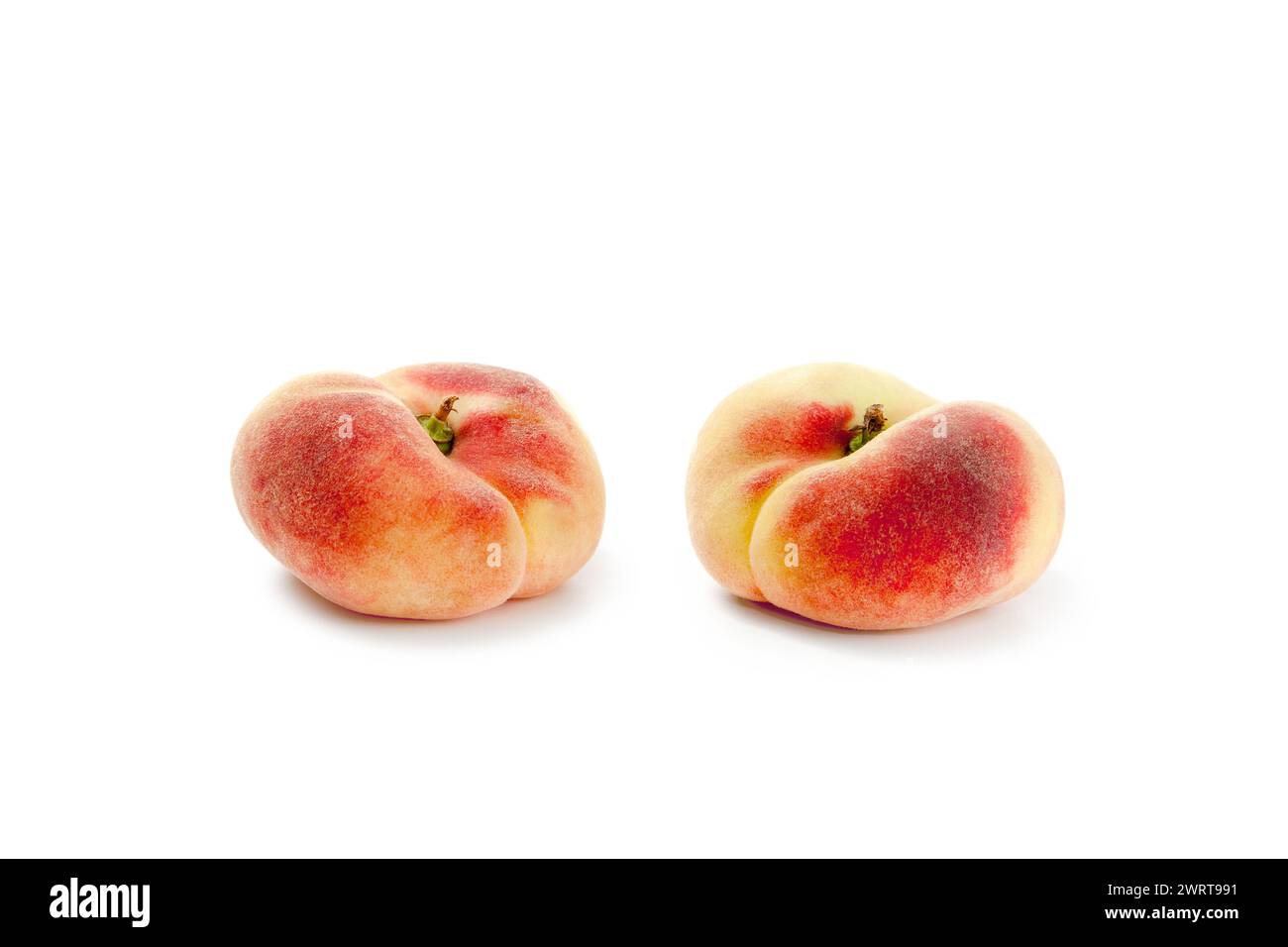 Two ripe chinese flat peach fruits or saturn peaches with soft shadow ...