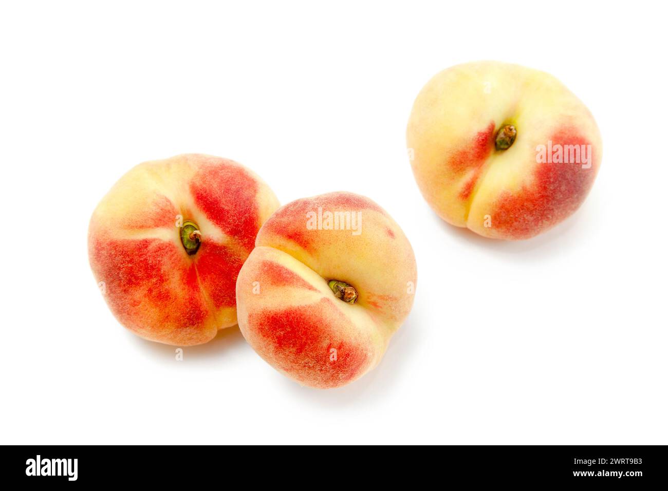 Three ripe chinese flat peach fruits or saturn peaches with soft shadow ...
