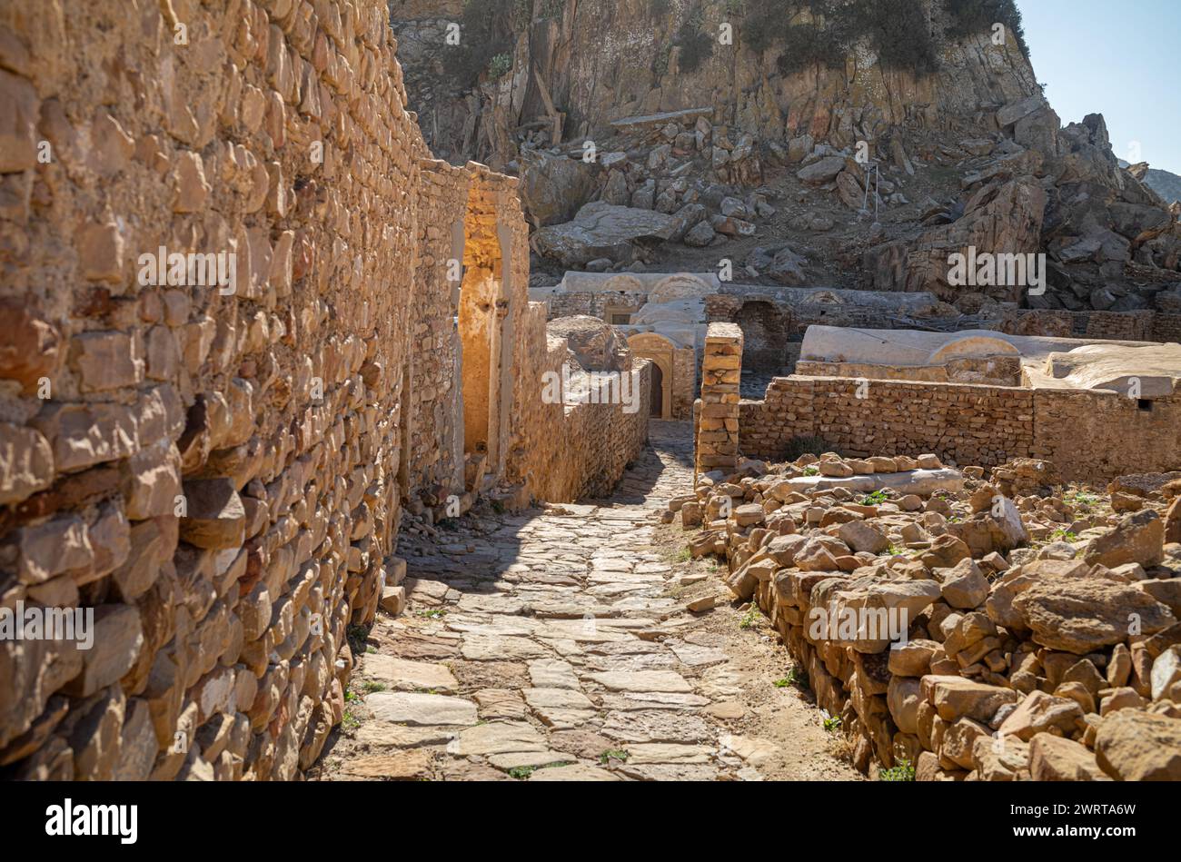 A stone alleyway past ruined houses in the abandoned hilltop Berber ...