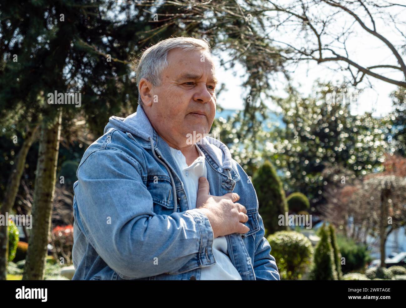 Worried elderly man experiencing chest pain while clutching his heart ...
