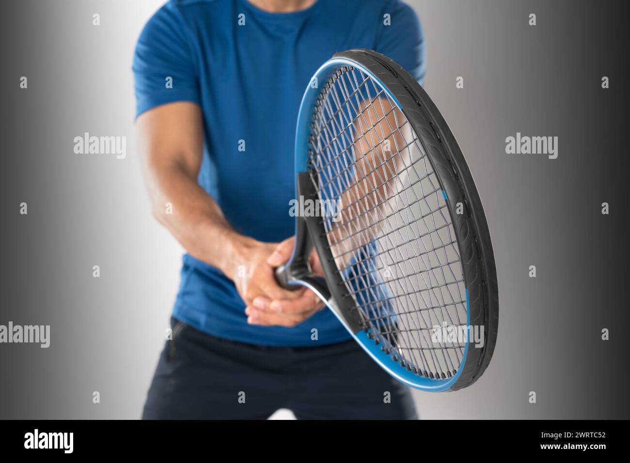 A male tennis player holding a tennis racket with a determined ...