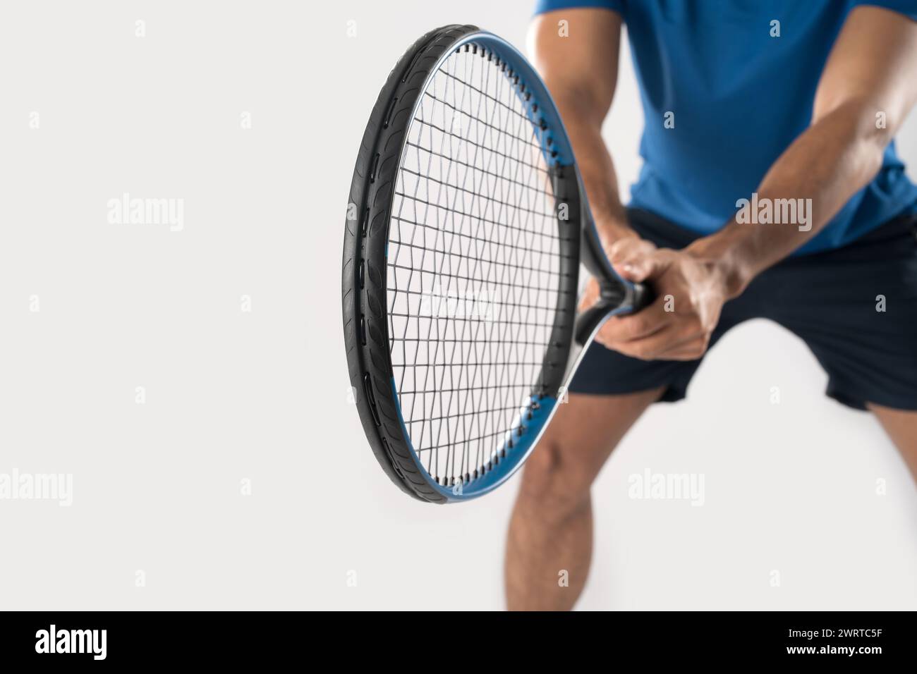 Male tennis player standing holding tennis racket with determination ...