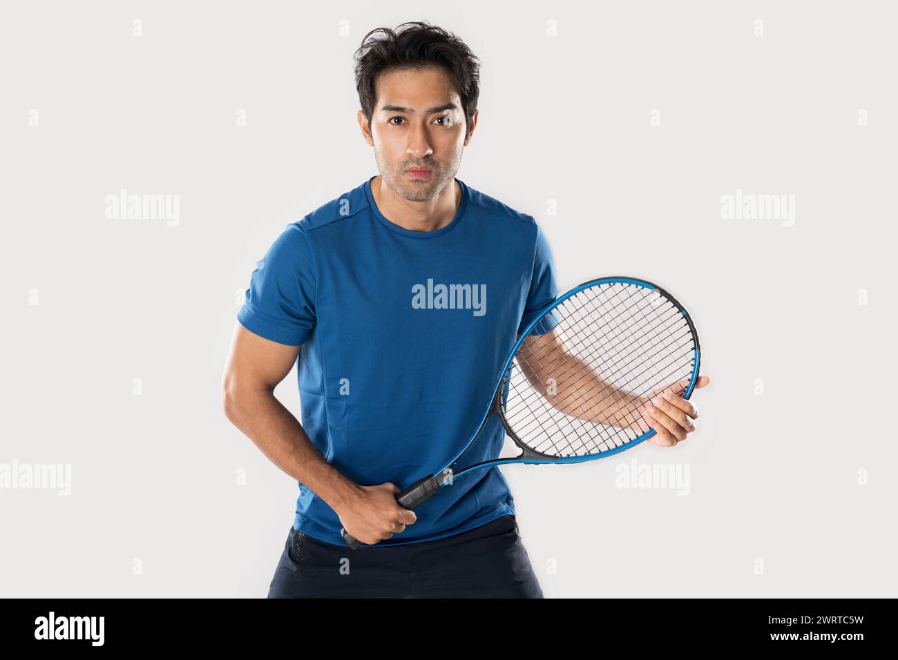 A male tennis player holding a tennis racket with a determined ...