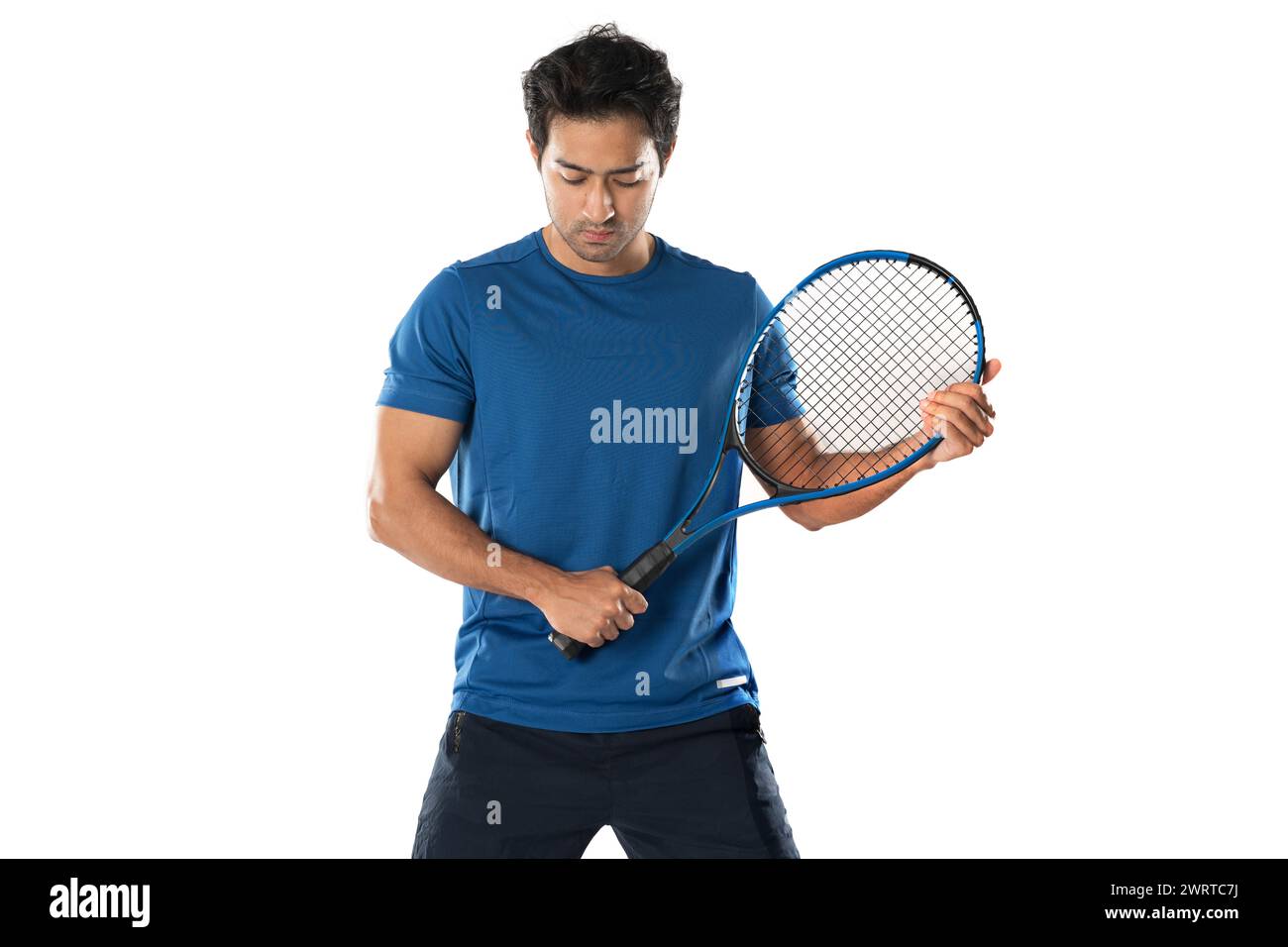 A male tennis player holding a tennis racket with a determined ...