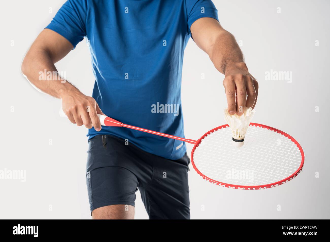 A badminton player in sportswear stands holding a racket and ...