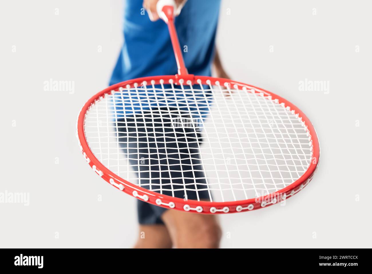 A badminton player in sportswear stands holding a racket and ...