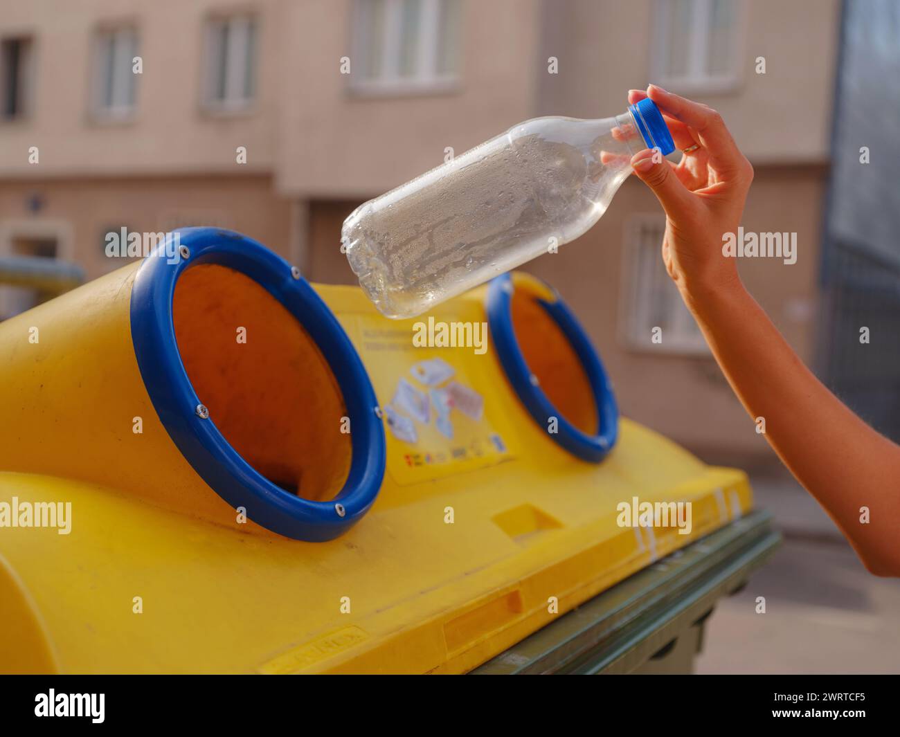 woman throwing plastic bottle Recycling bin stand on european street ...
