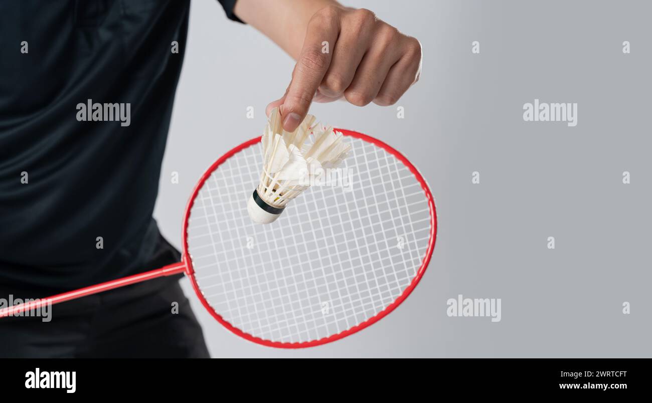 A badminton player in sportswear stands holding a racket and ...