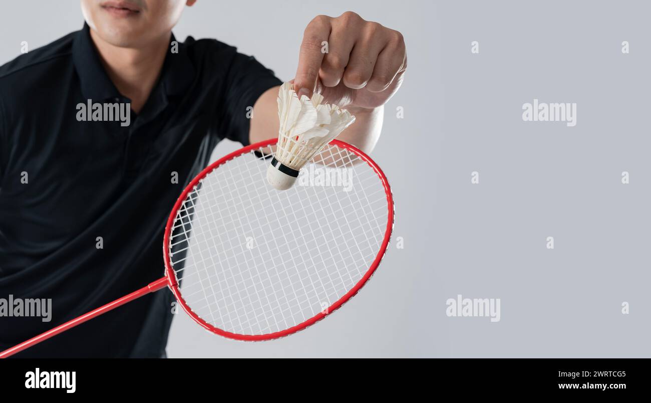 A badminton player in sportswear stands holding a racket and ...