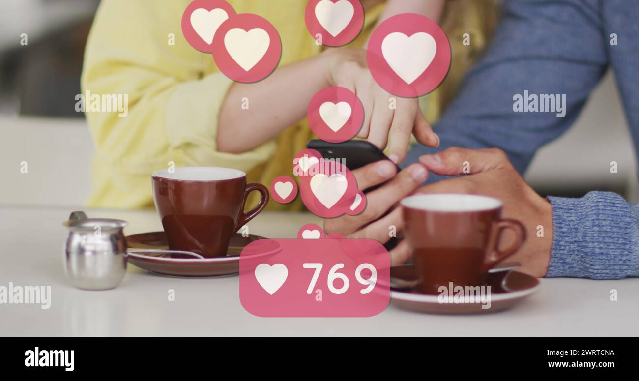 Image of heart icons floating over caucasian couple using smartphone ...